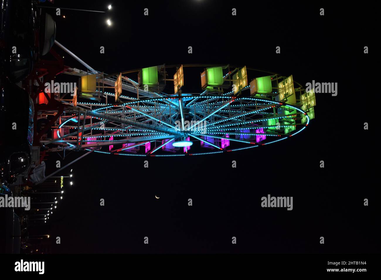 Vertical shot of the Ferris wheel in the nighttime decorated with led ...