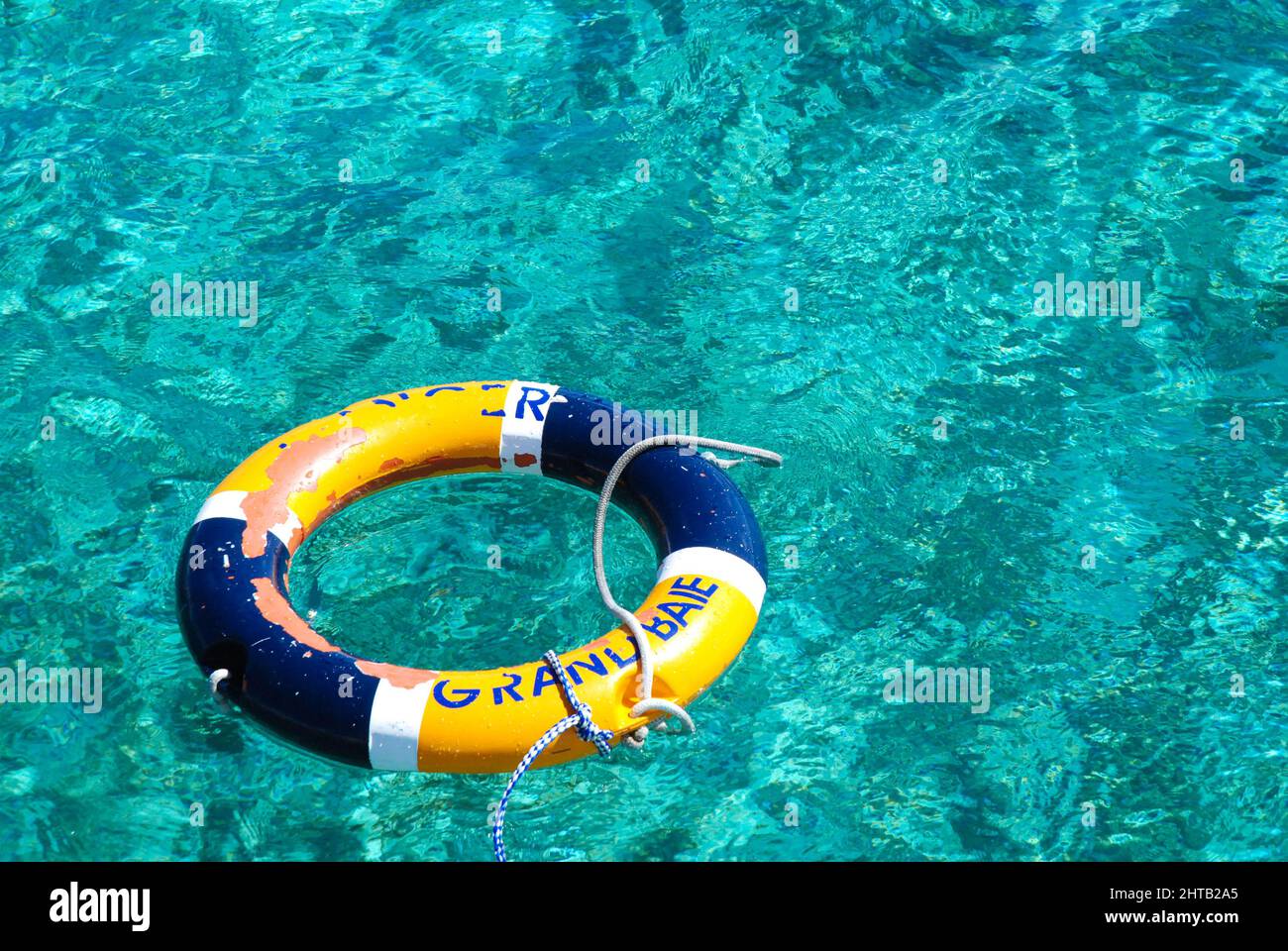 Yellow and blue lifesaver ring in ocean in Grand Baie Stock Photo - Alamy