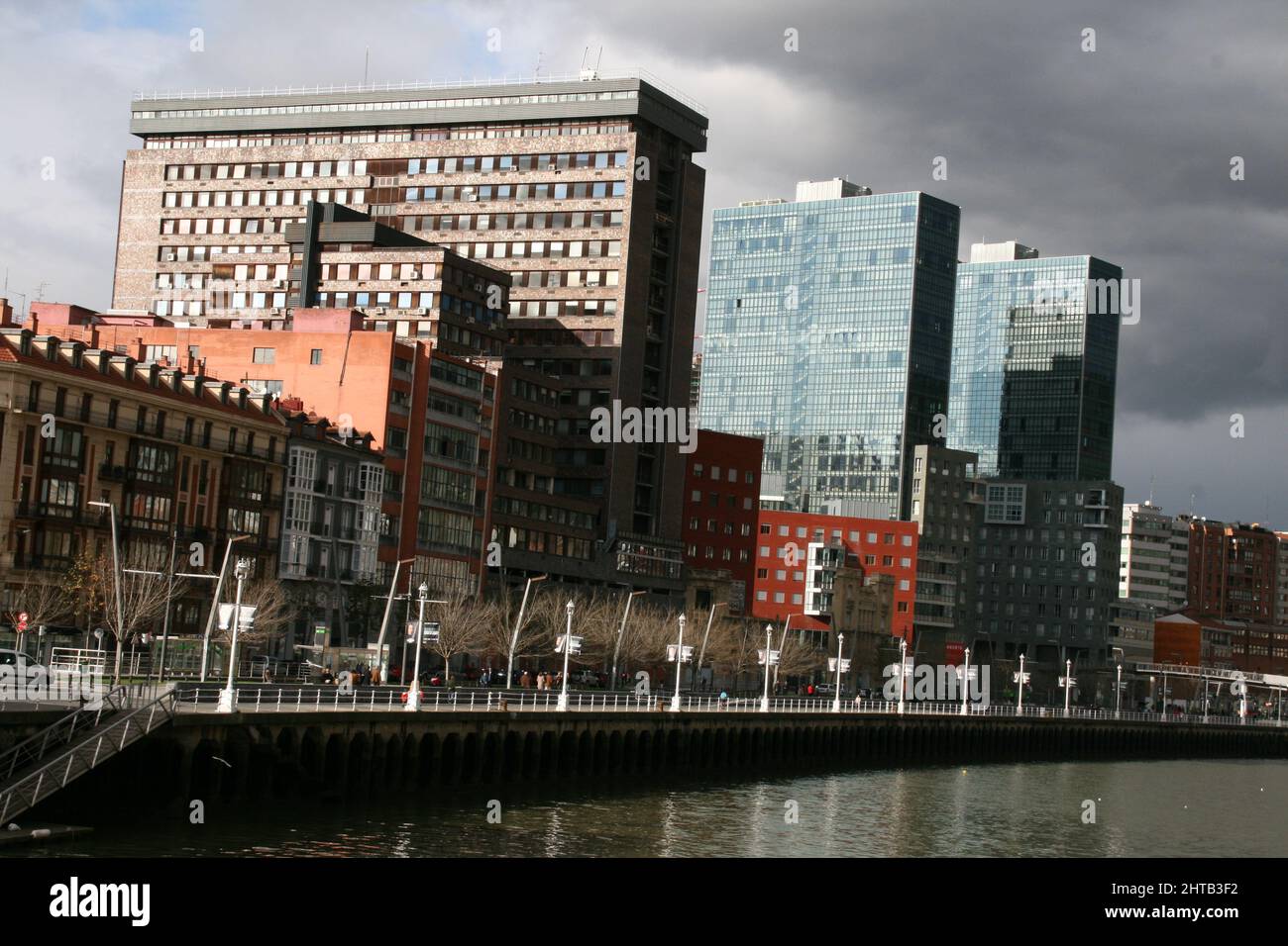 A three buildings two with a glass facade and the other stone-faced in ...