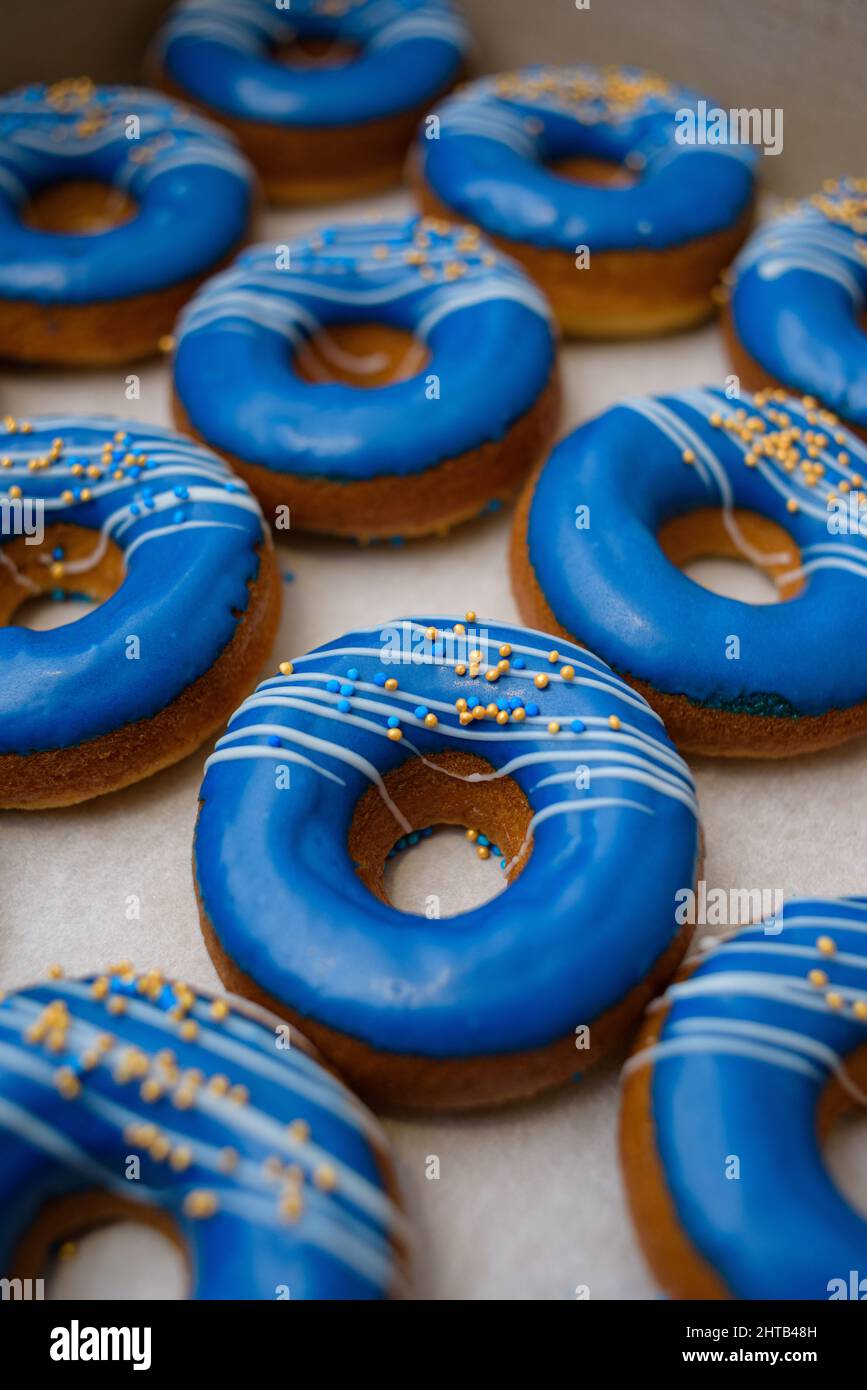 Vertical photo of donuts with blue icing and edible golden pearls Stock ...