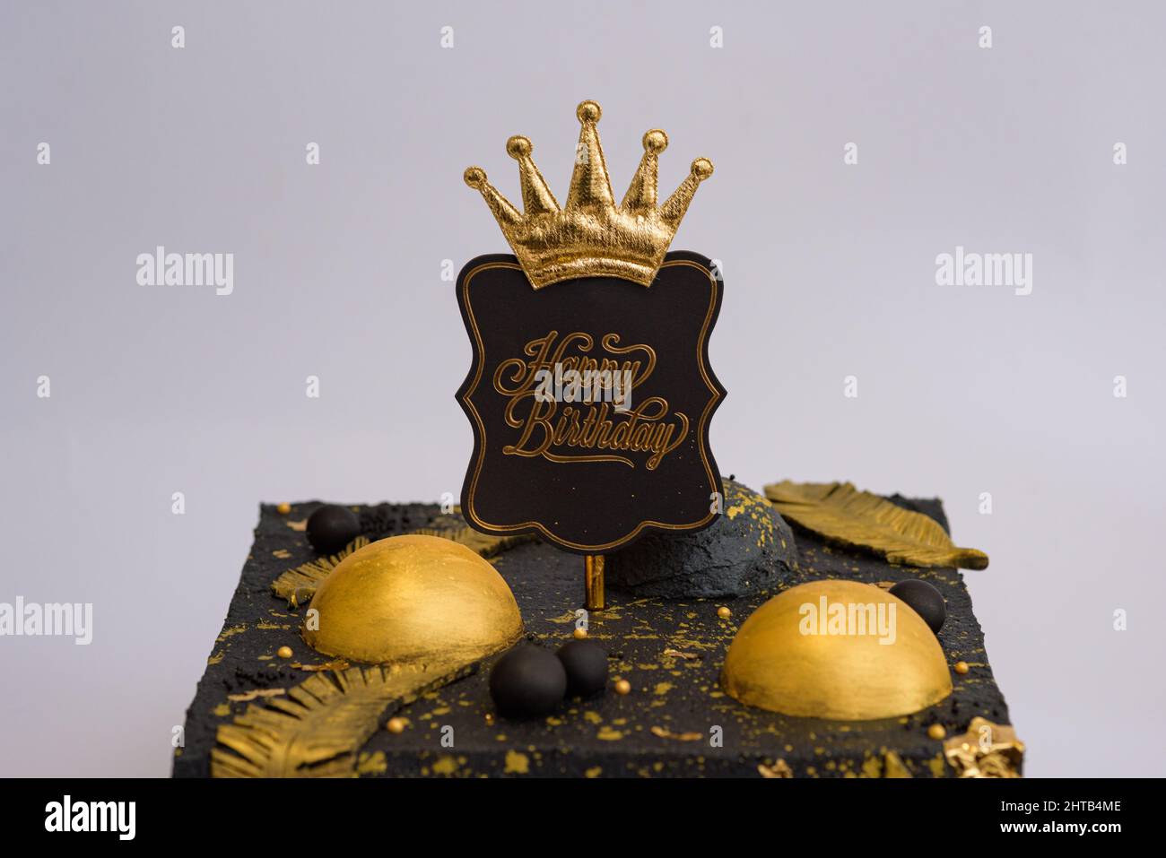 Photo of a black mouse birthday cake with golden splatter and ...