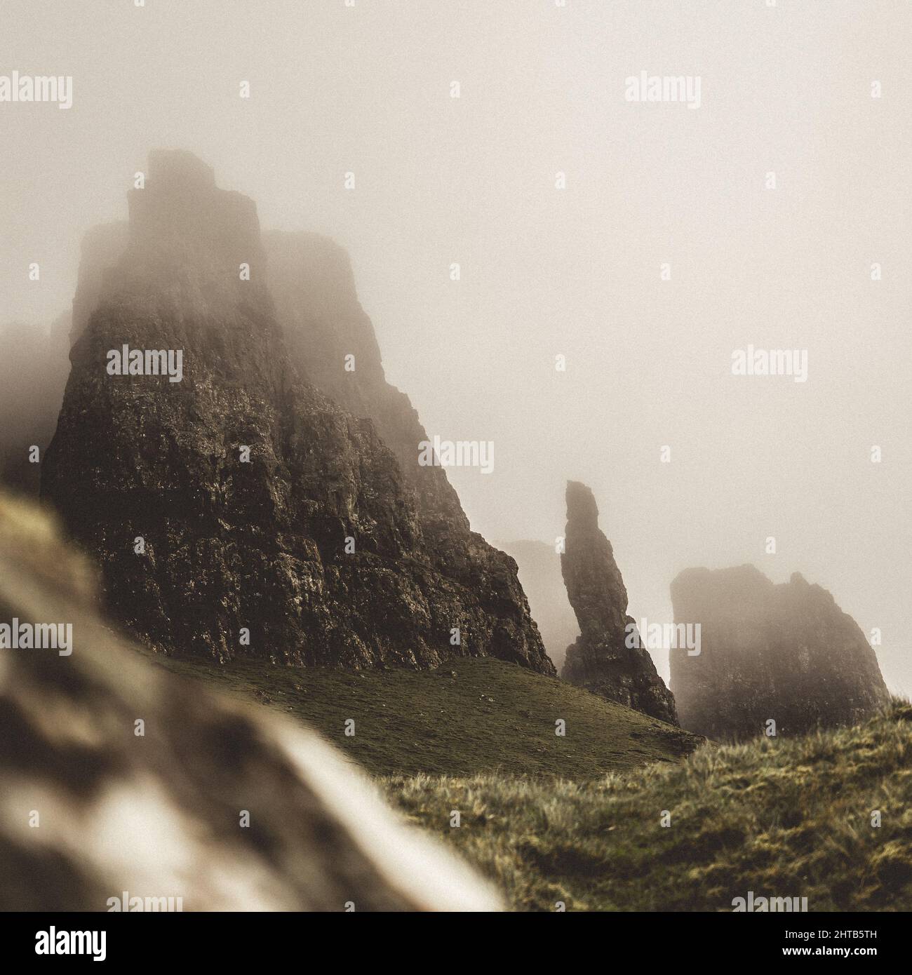 Scenic portrait of foggy rock formations in the Isle of Skye in the ...