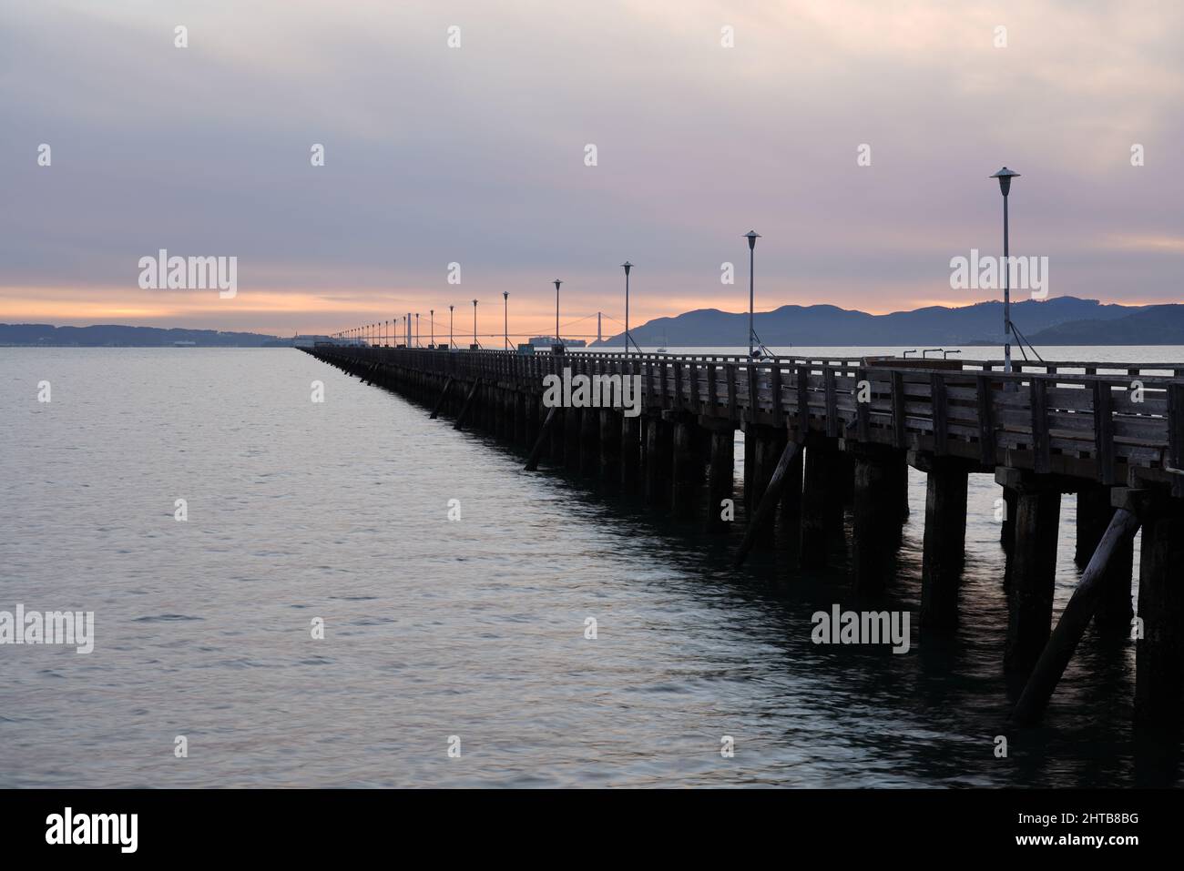 Scenic view of a long coastal road over a calm sea during sunset Stock ...