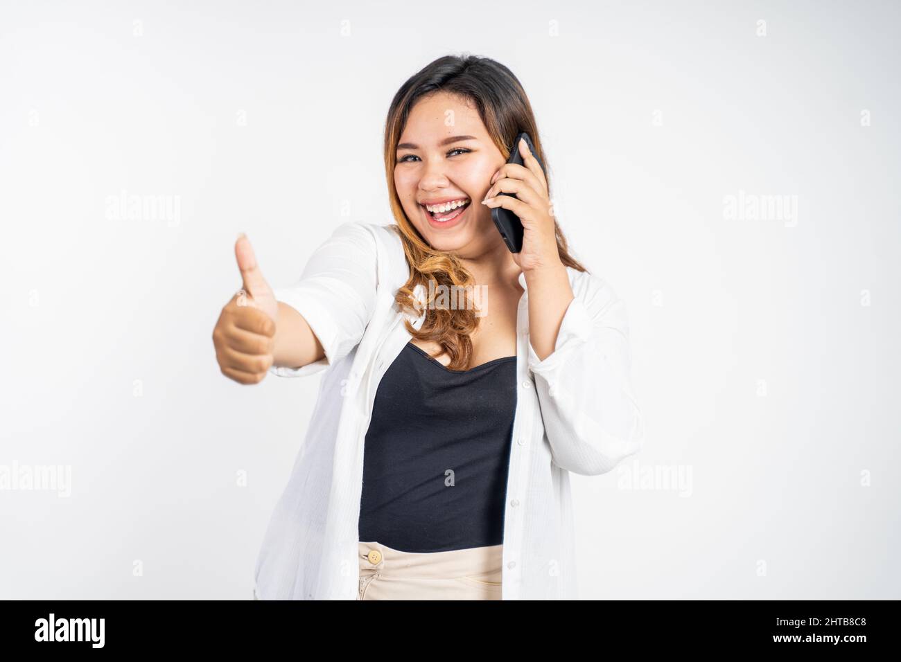 woman making a call using a mobile phone with thumbs up Stock Photo - Alamy