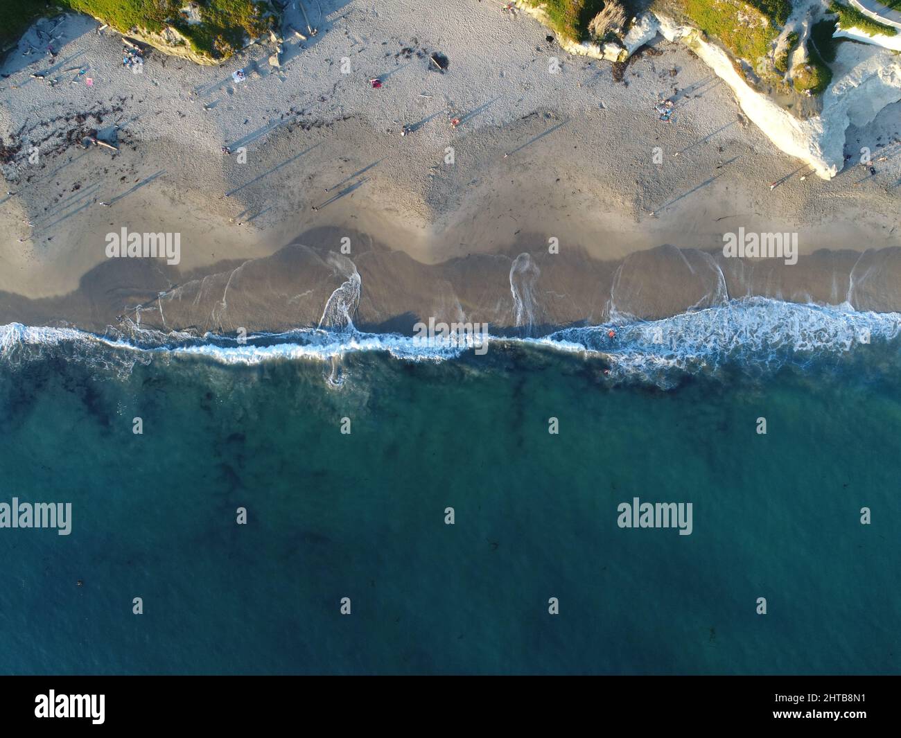 Top view of the sandy shoreline and turquoise water intersecting in the ...
