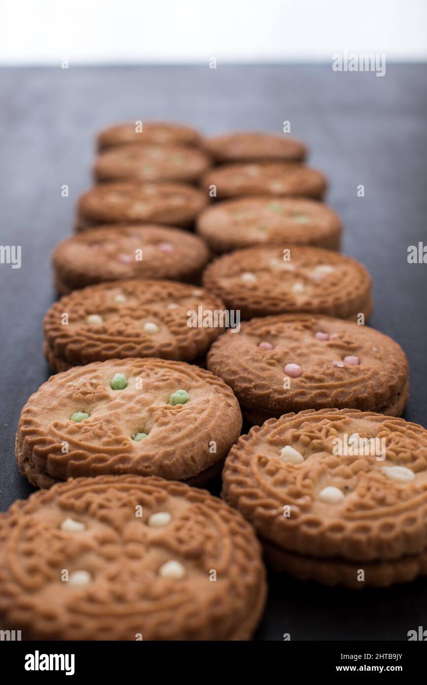 Vertical shot of round biscuits with various fillings on a black ...