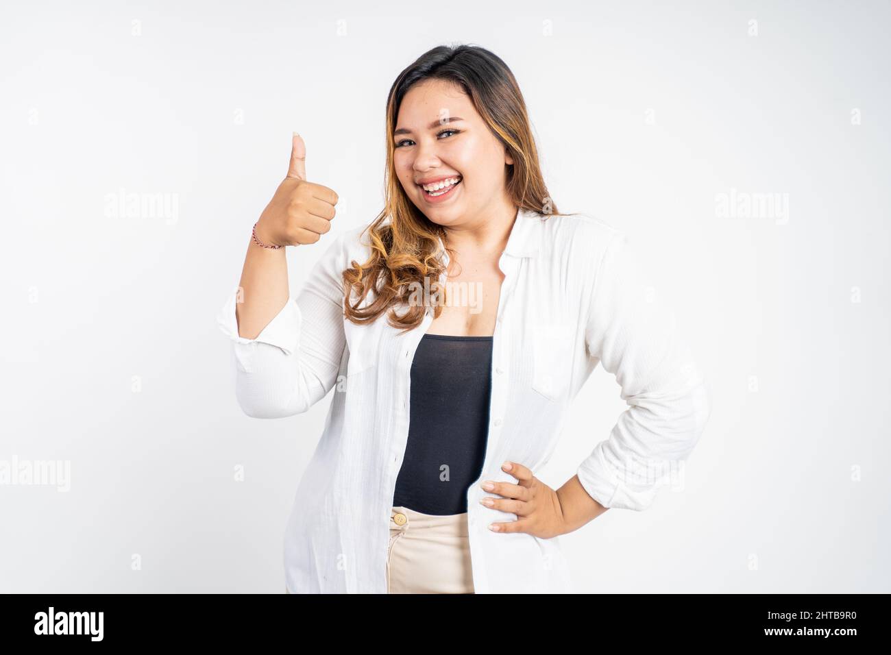 smiling young woman stand with thumbs up on isolated background Stock ...