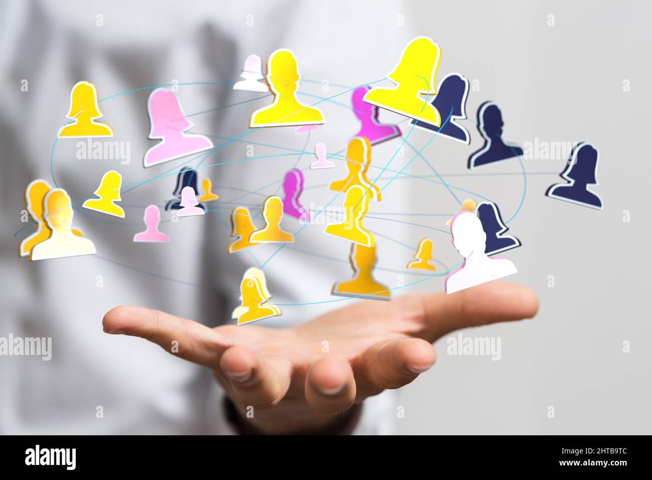 Shallow focus shot of a human hand holding interconnected human icons ...