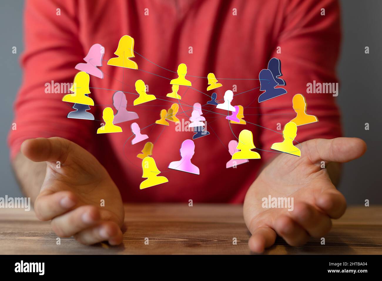 Shallow focus shot of human hands holding interconnected human icons ...