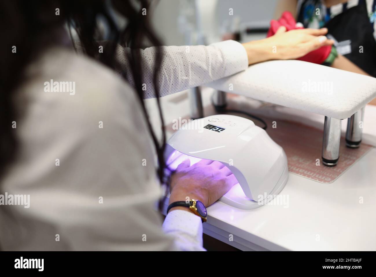 Lady drying gel in ultraviolet lamp Stock Photo - Alamy