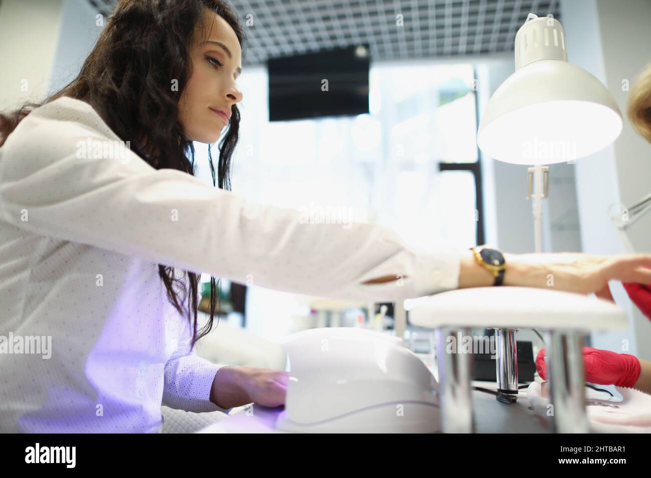 Female person drying gel in lamp Stock Photo - Alamy