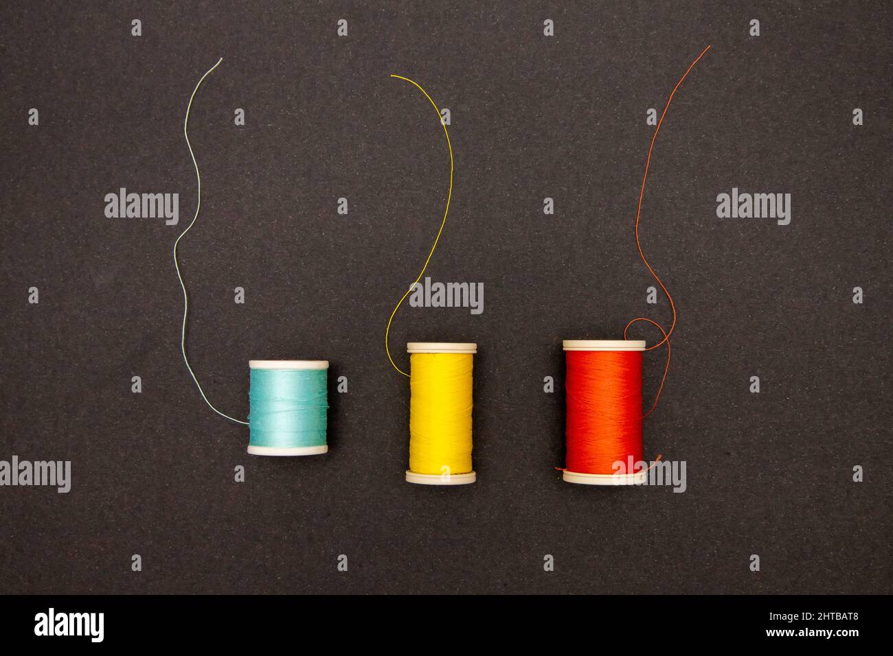 Closeup of thread reels on a black background Stock Photo - Alamy