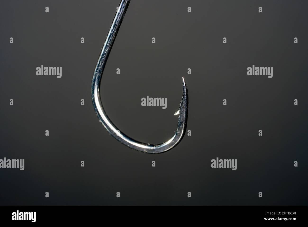 Closeup of a metal hook with gray background Stock Photo - Alamy