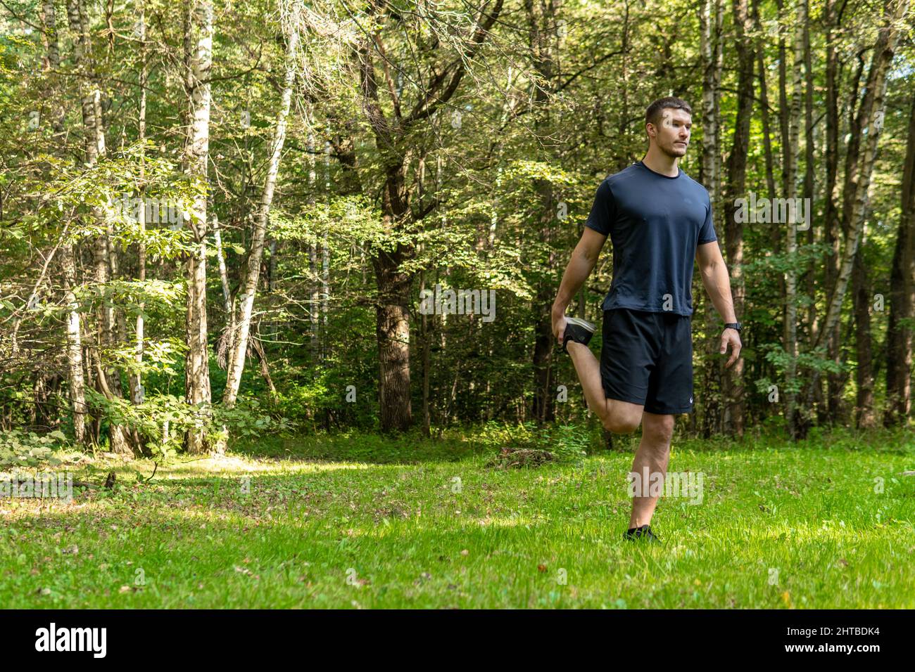 A man athlete runs in the park outdoors, around the forest, oak trees ...
