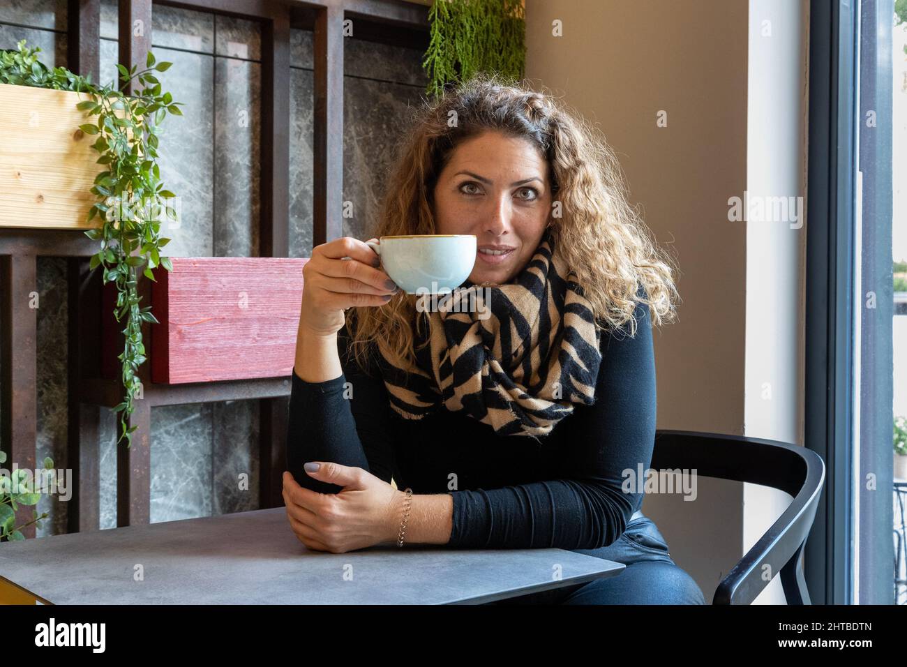 Beautiful White Caucasian Woman With Wavy Hair Drinking Coffee In A