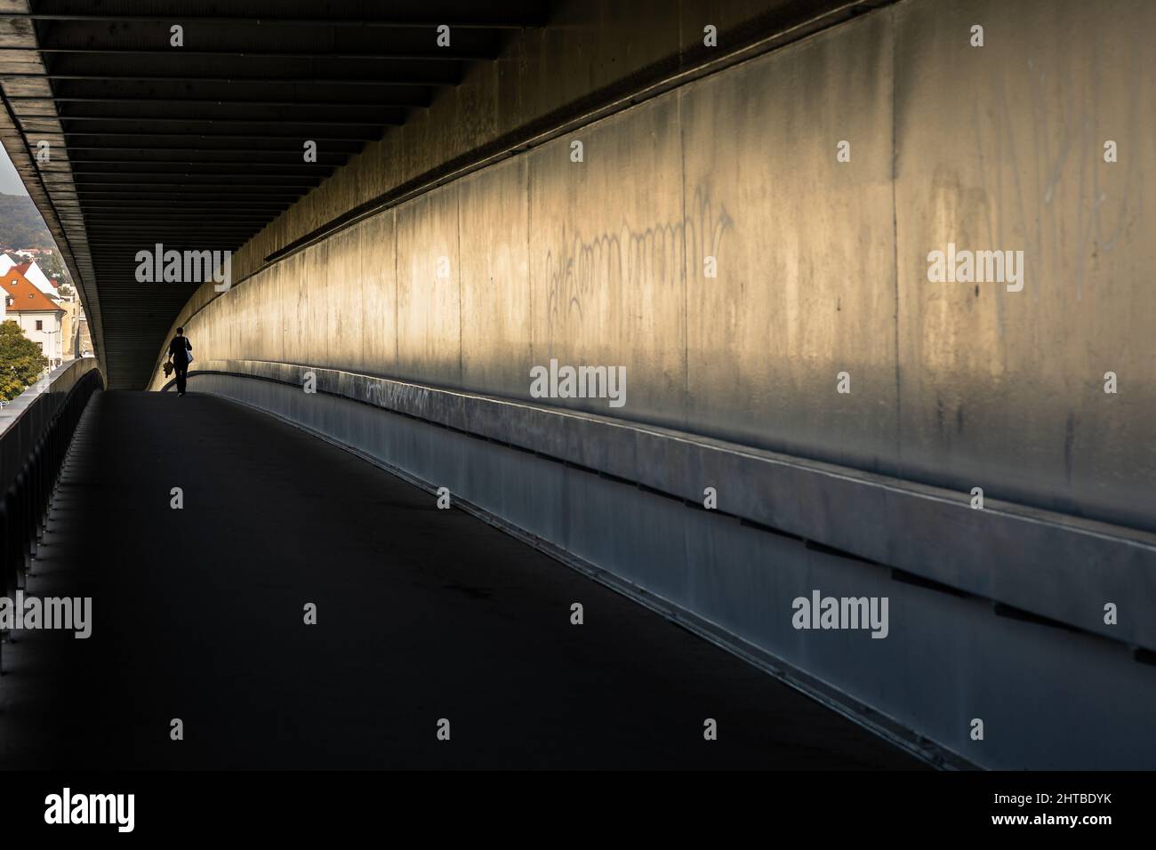 Lonely person walking under the bridge Stock Photo - Alamy