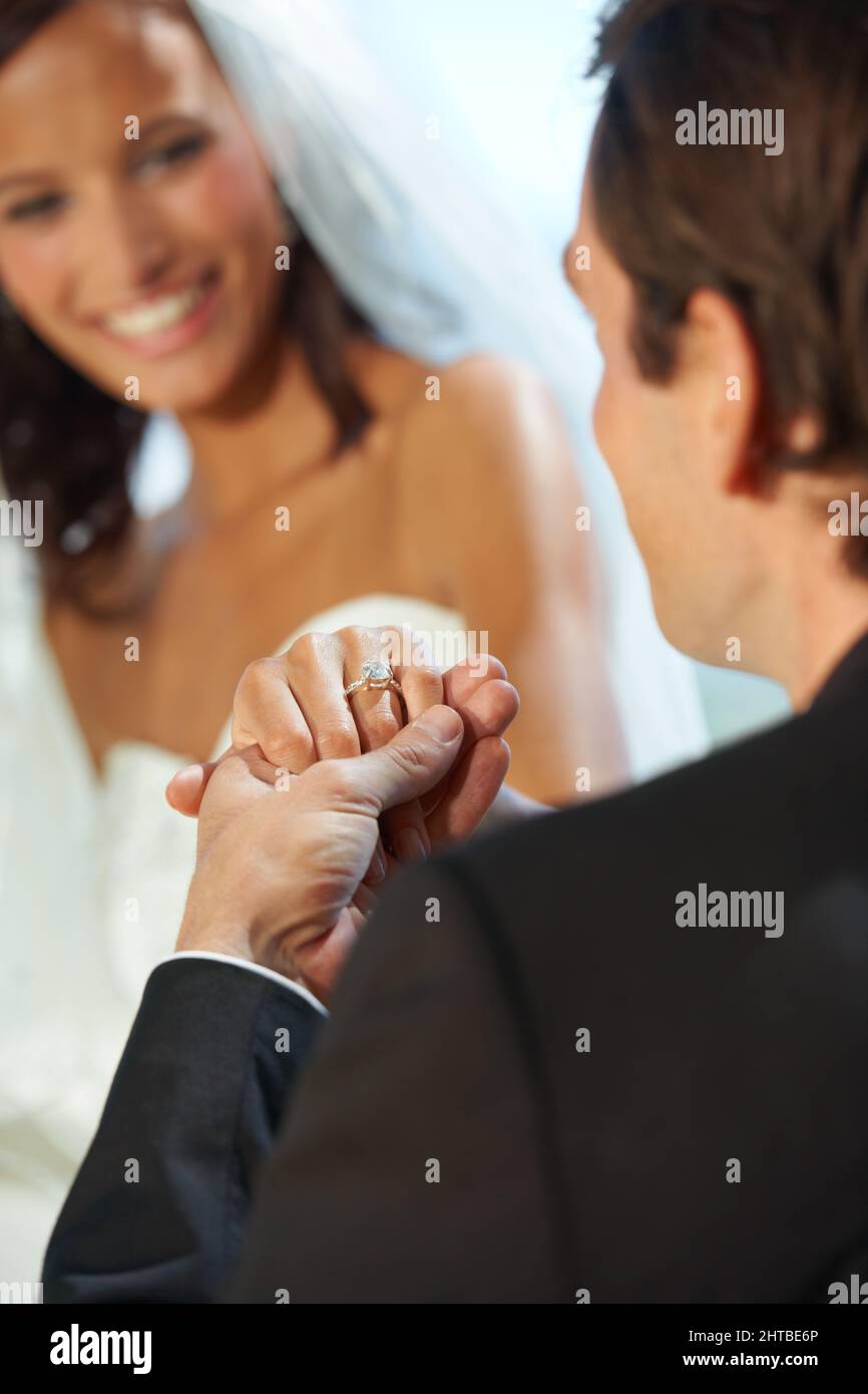 Making promises to love and honor. Cropped view of a groom holding his ...