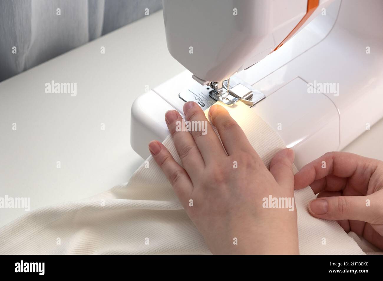 Real middle aged woman tailor sewing clothes using a sewing machine at ...