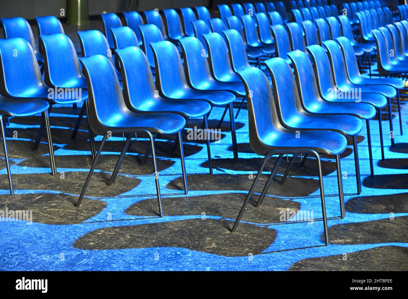 View of empty audience seats arranged in rows under the blue ...