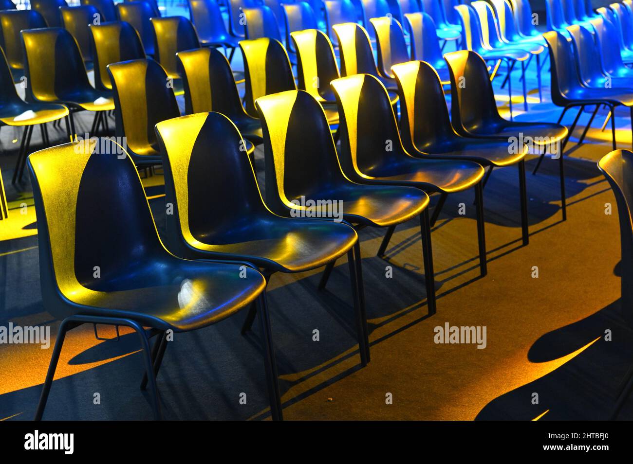 View of empty audience seats arranged in rows under the yellow ...