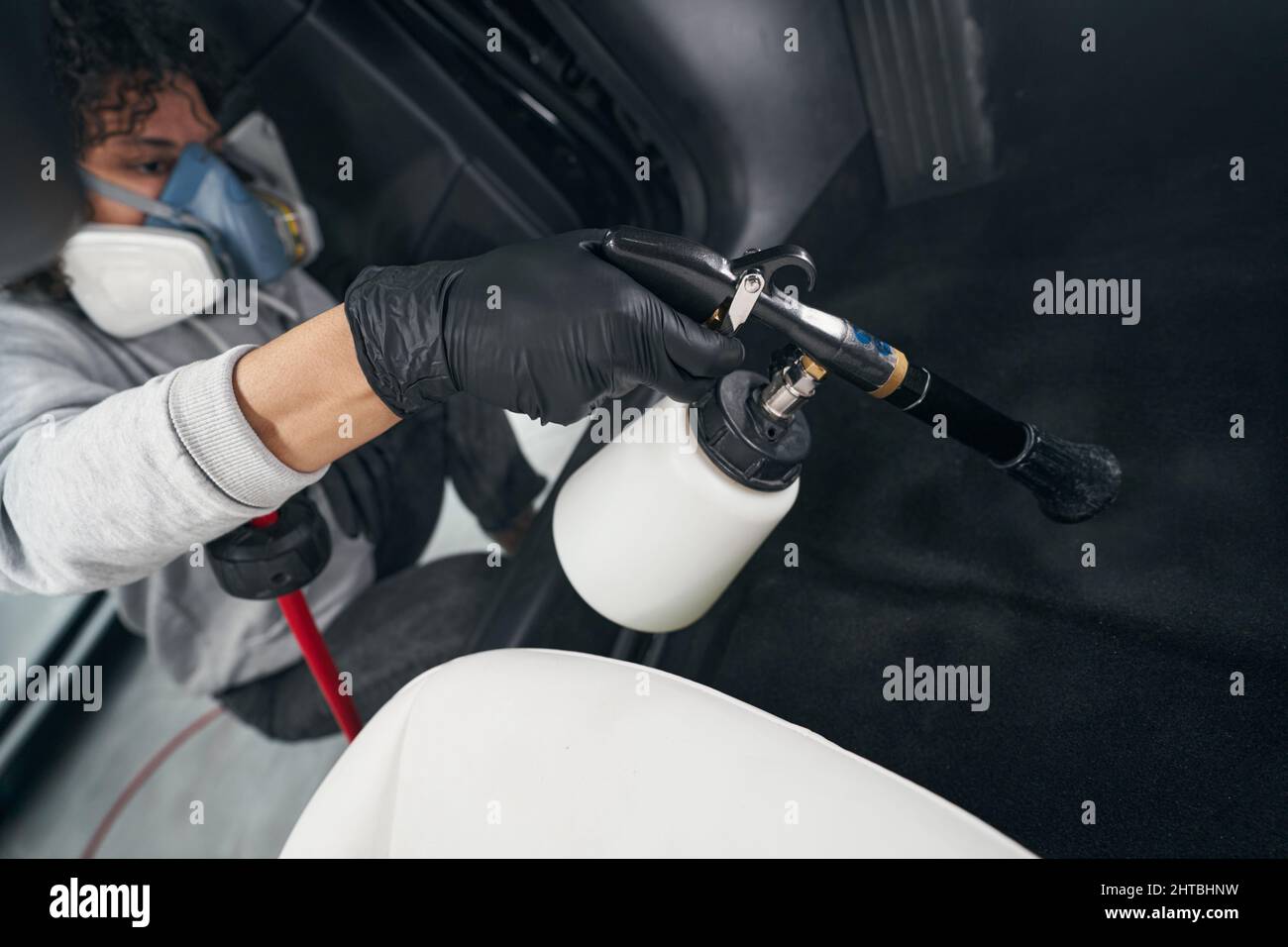 Detailer applying auto interior air pulse cleaning gun Stock Photo - Alamy