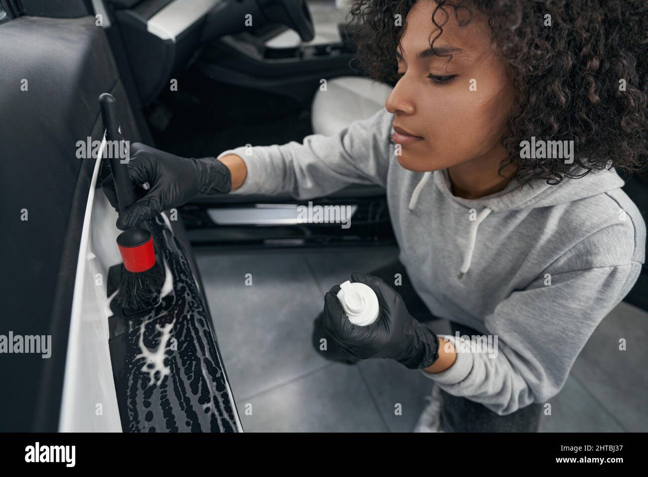 Professional detailer cleaning interior of customer vehicle Stock Photo ...