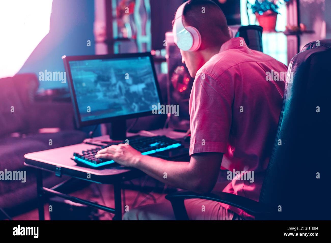 Back of gamer playing a video game on a computer Stock Photo - Alamy