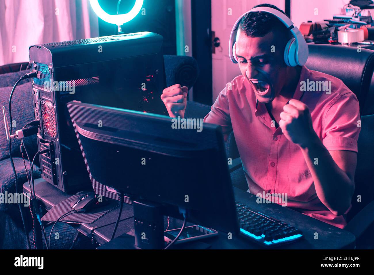 Young latin arms making a winner gesture in front of a gamer computer ...