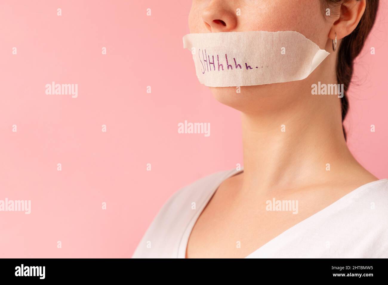 Portrait of a Caucasian woman with her mouth taped shut. Tape has the ...