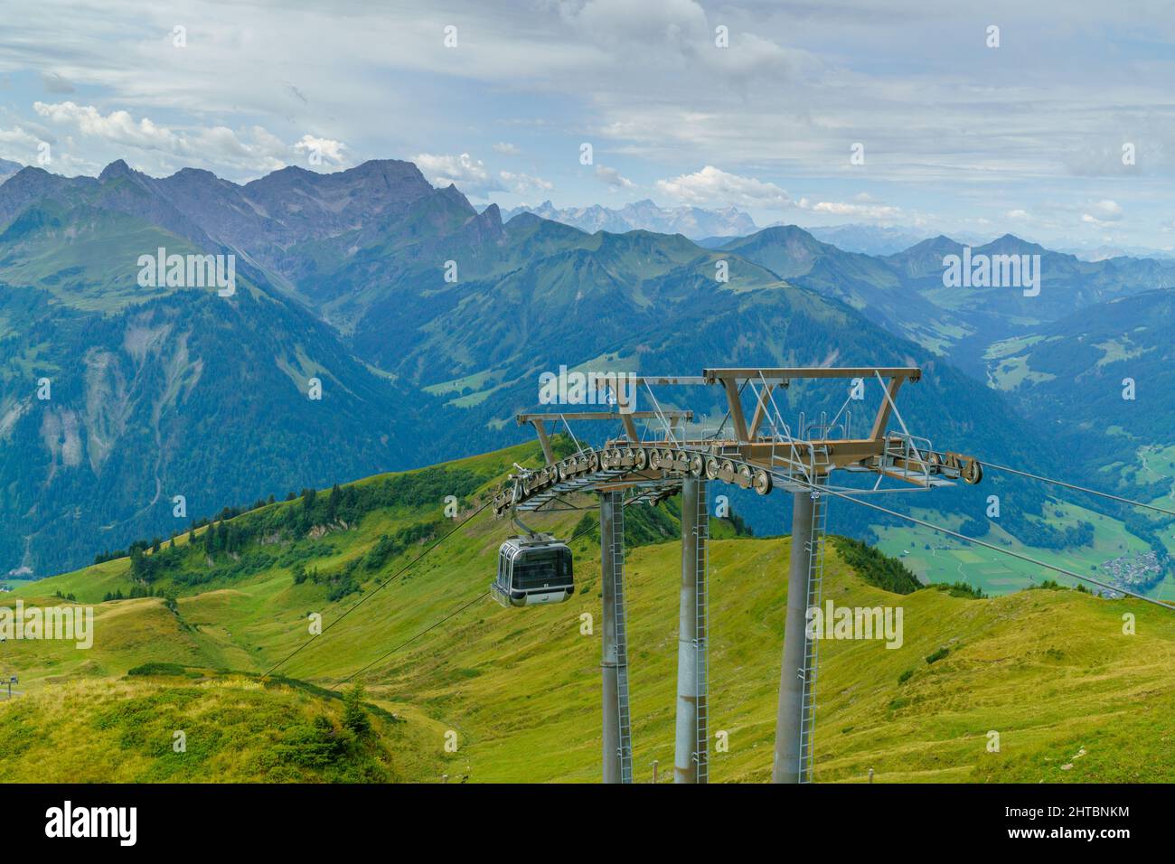 Ropeway with the background of a green field and mountains Stock Photo ...