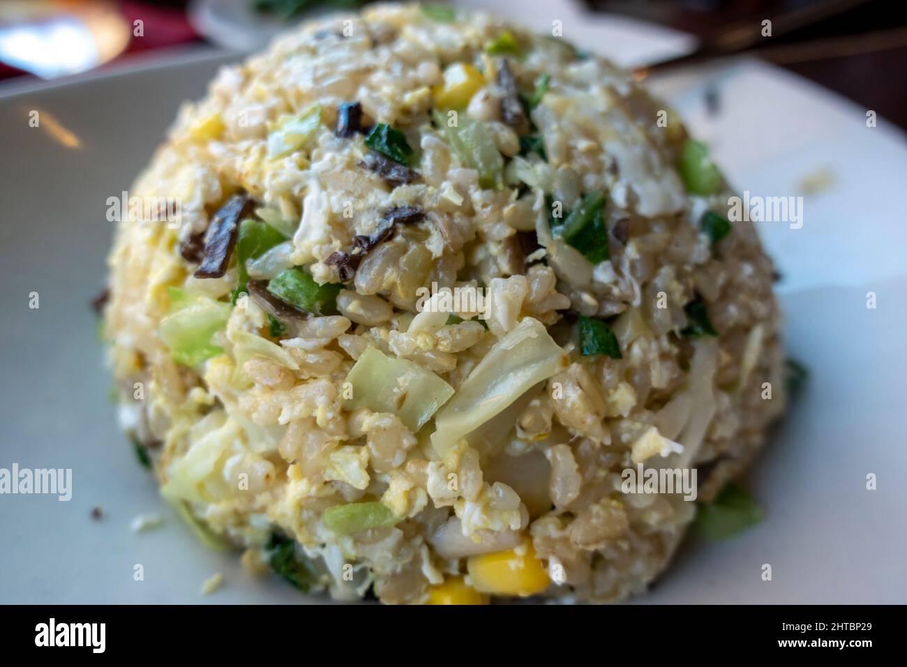 View of a round scoop of vegetable and mushroom fried rice on a small ...