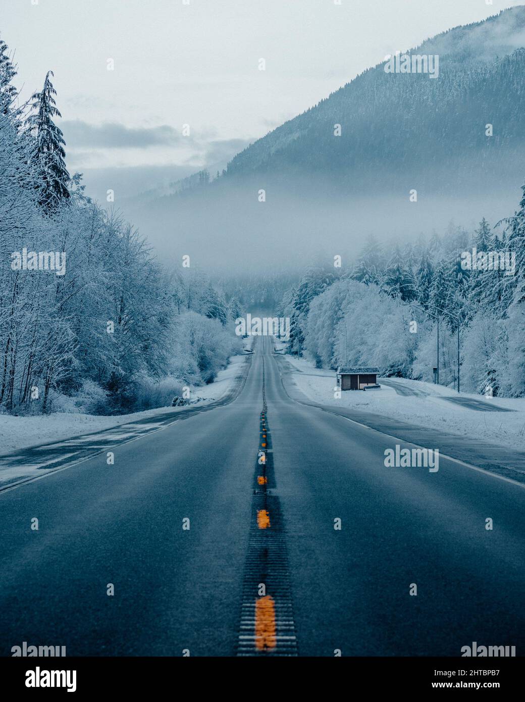 Frozen highway surrounded by hills covered in the snow and fog in ...