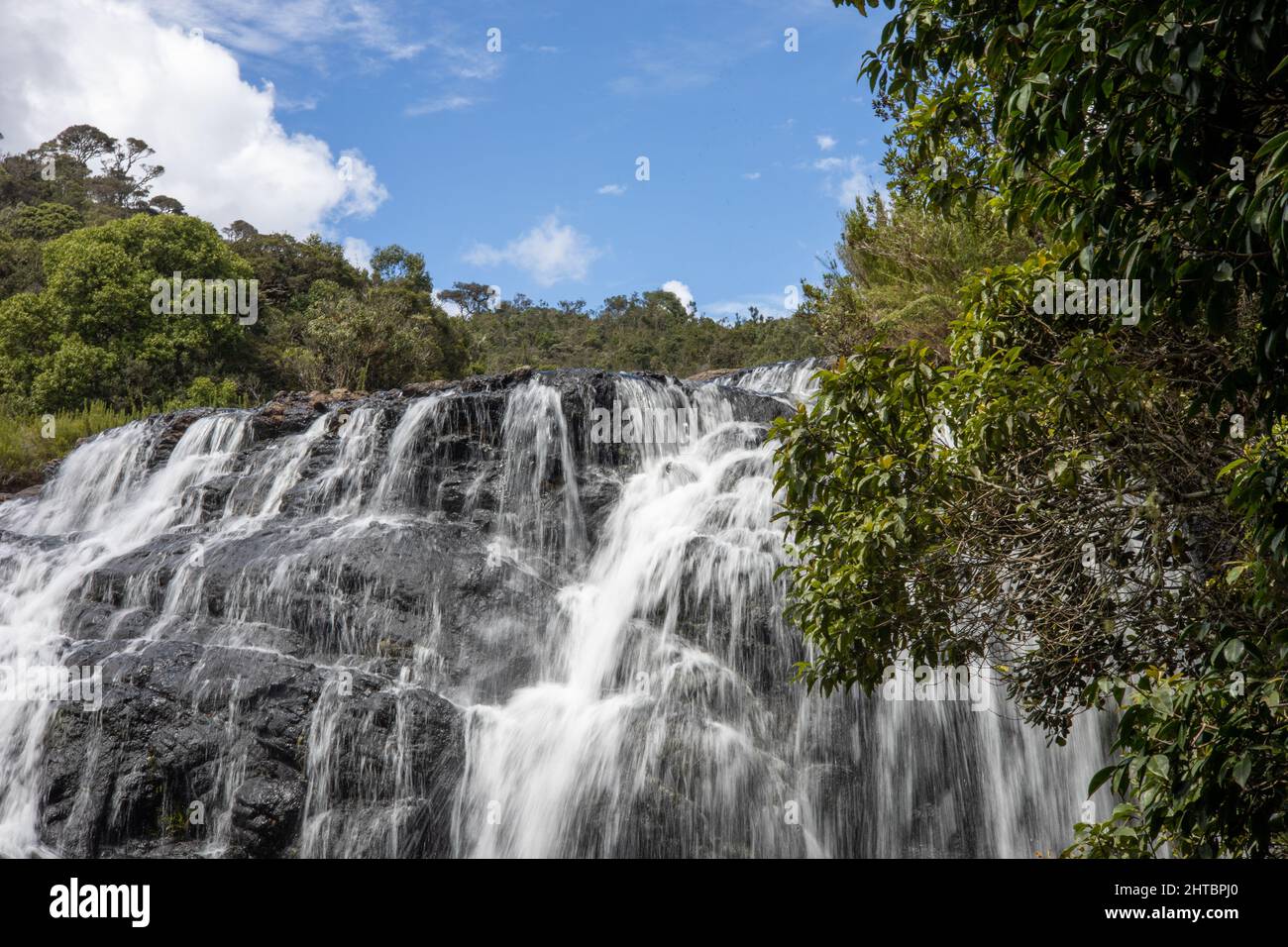 Blue sky over the waterfall and green plants in Horton Plains National ...