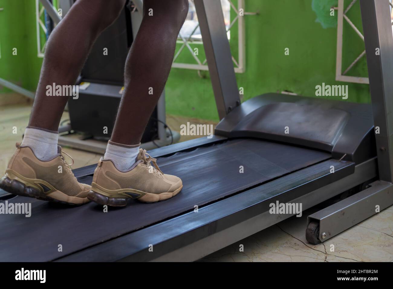 Young athletic African man running on a treadmill in a gym Stock Photo ...