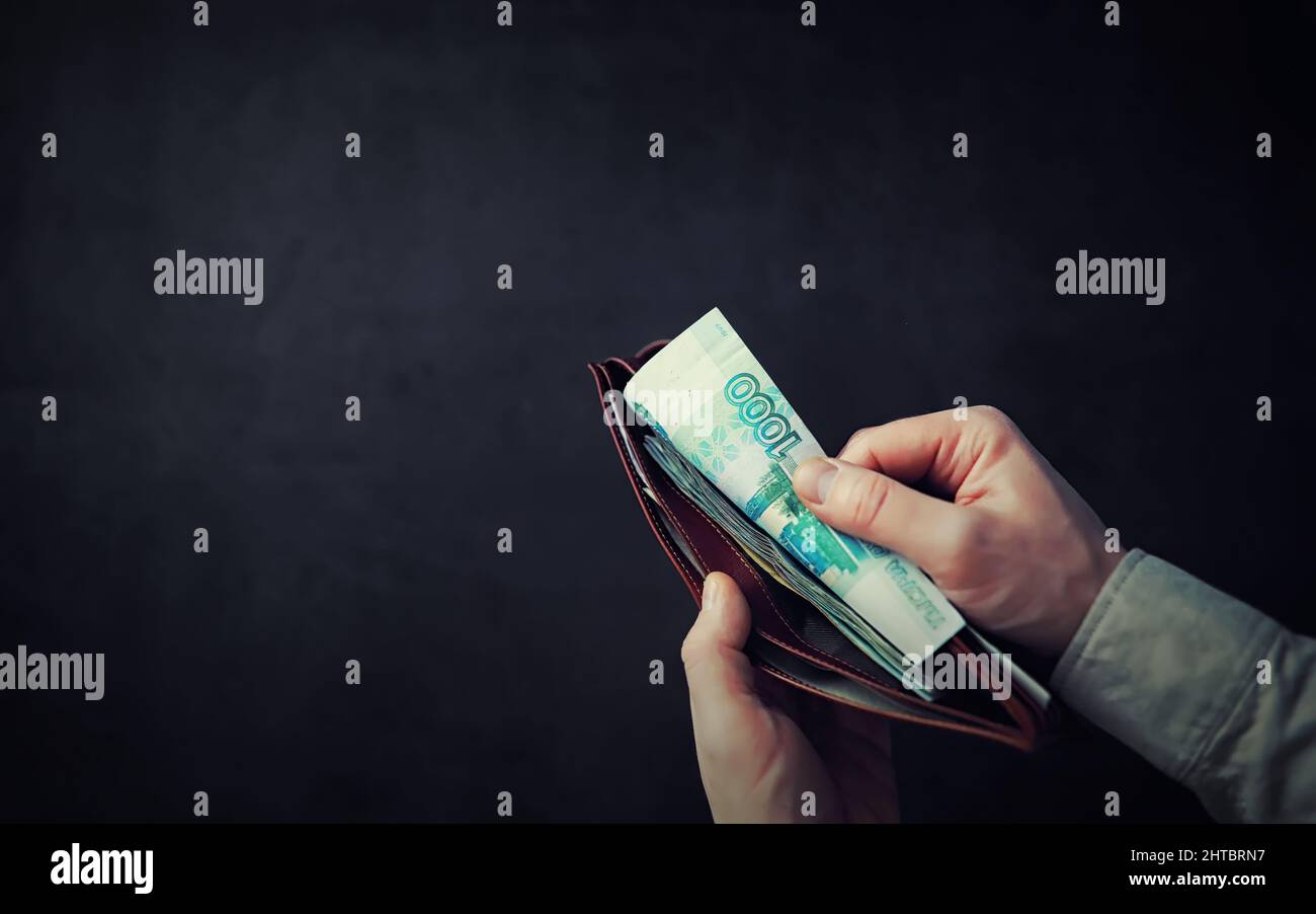 Hands take out cash banknotes from a wallet on gray background. Foreign ...