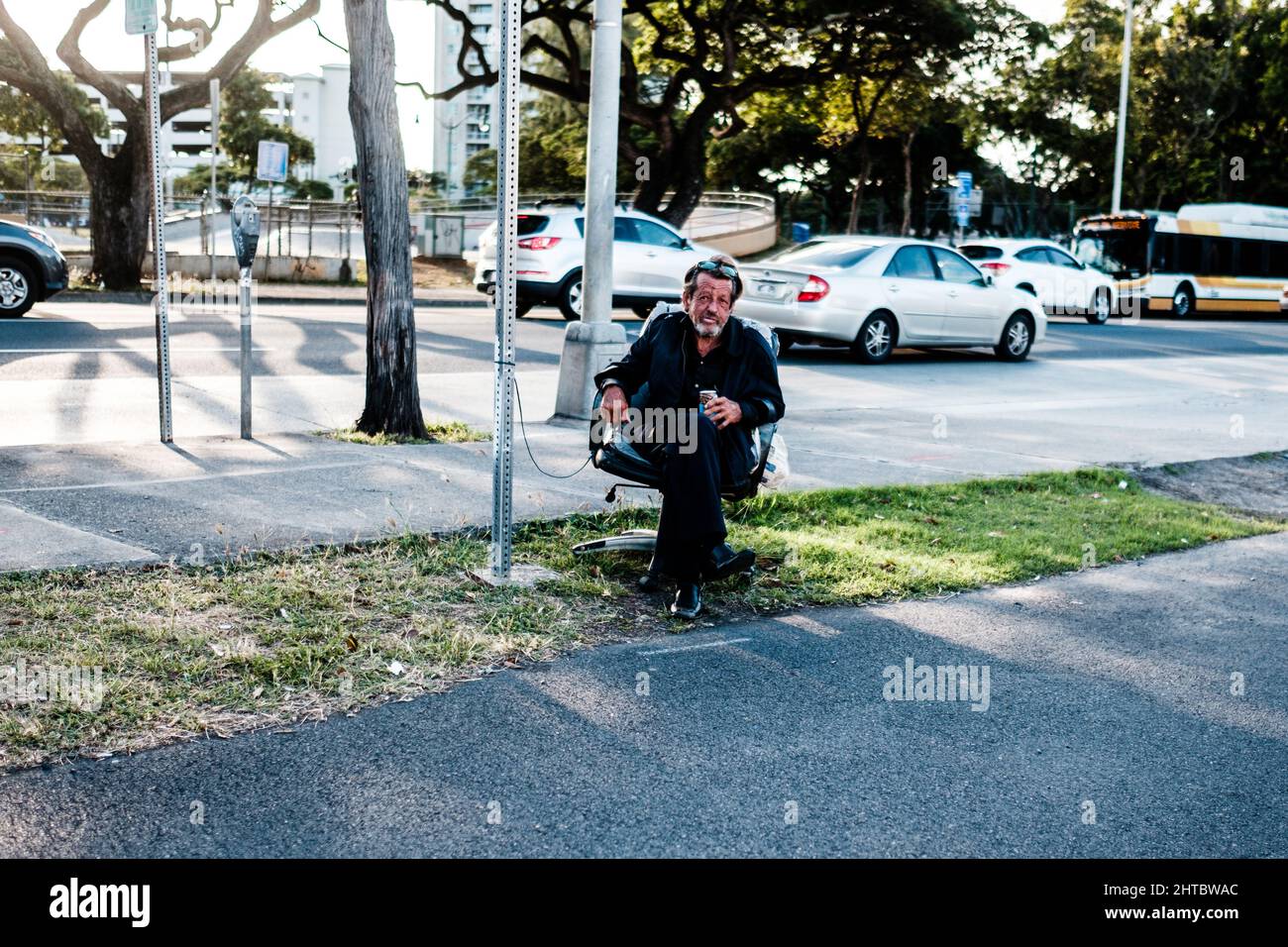 Poor, old man relaxing, sitting on a chair at a sidewalk Stock Photo ...