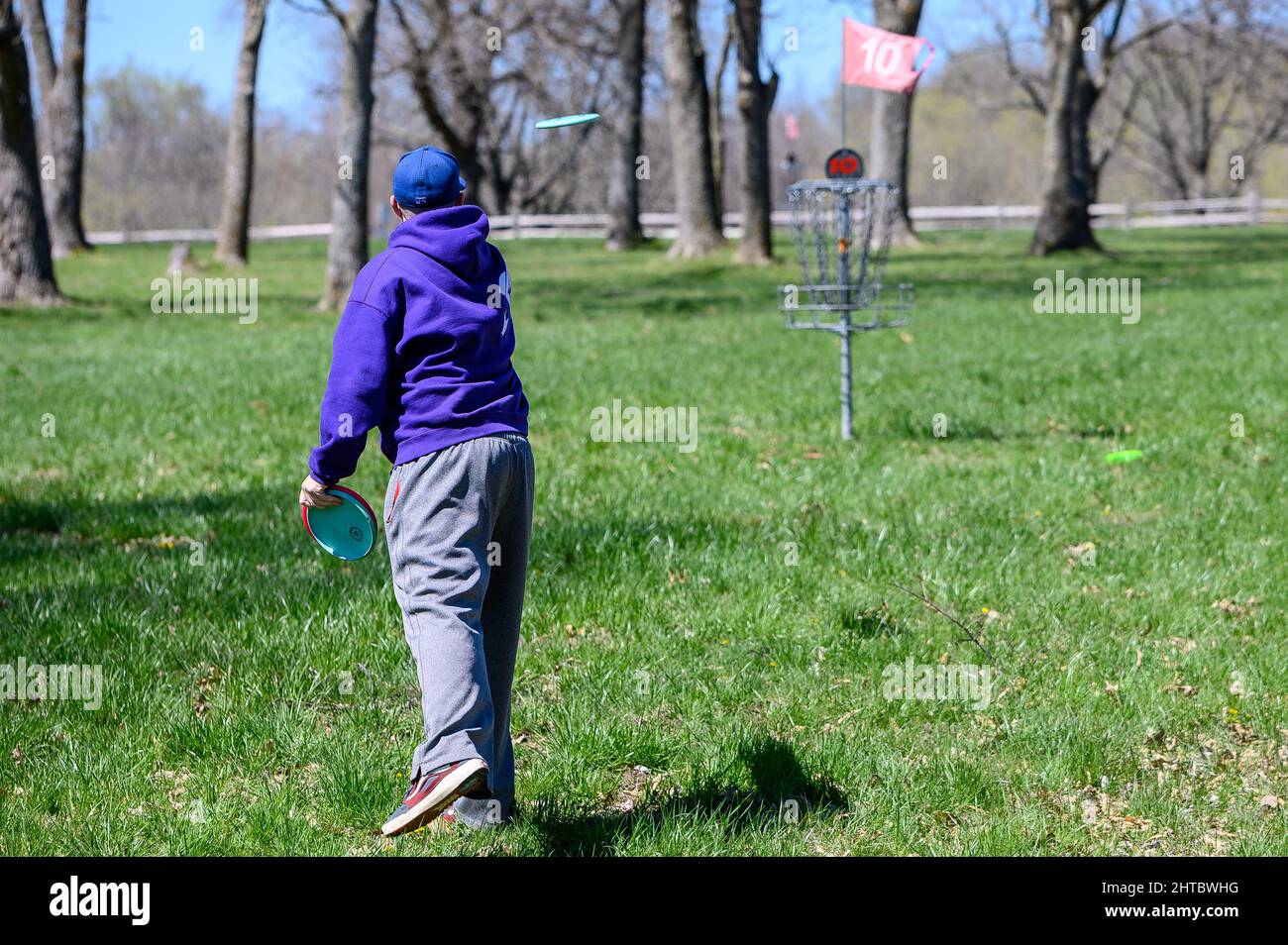 Disc golf player throwing a disc in the park Stock Photo - Alamy