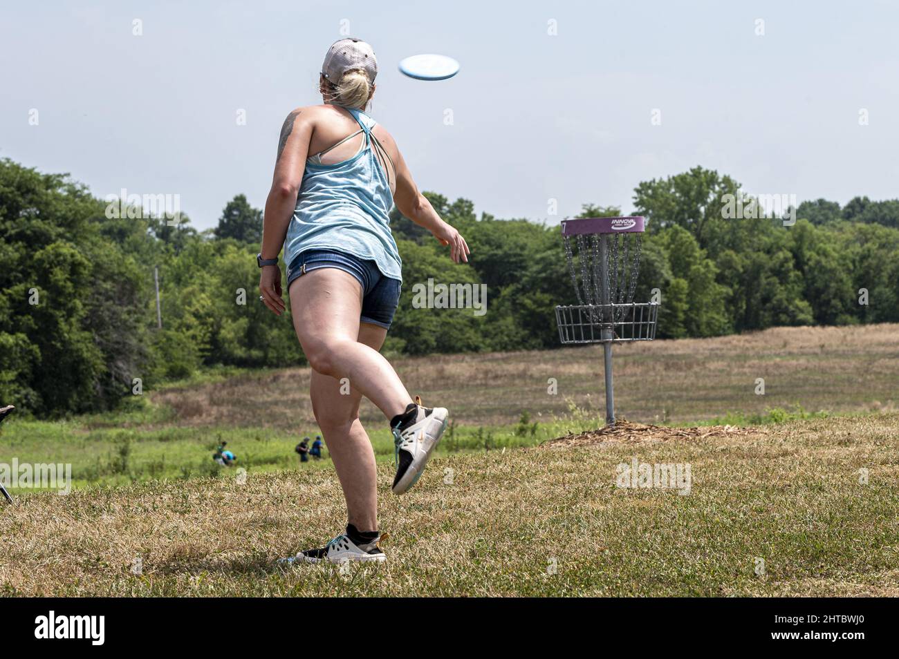 Woman playing disc frisbee golf Stock Photo - Alamy