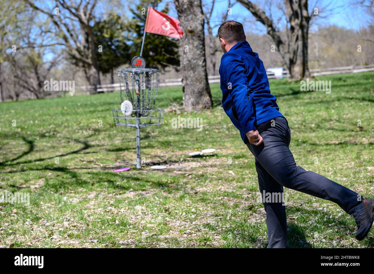 Disc golf player throwing a disc in the park Stock Photo - Alamy