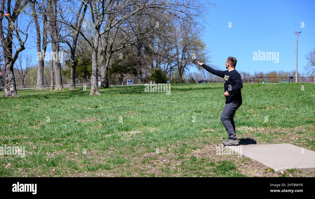 Disc golf player throwing a disc in the park Stock Photo - Alamy