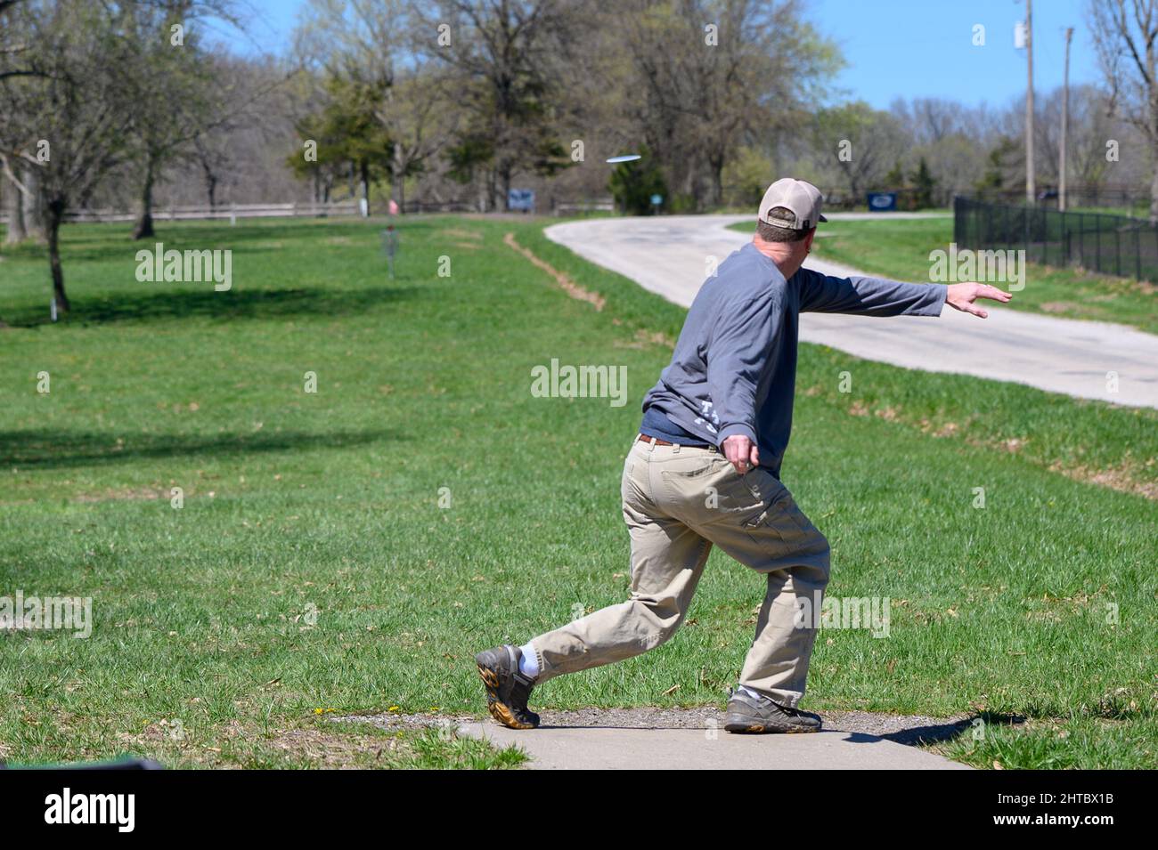 Disc golf player throwing a disc in the park Stock Photo - Alamy
