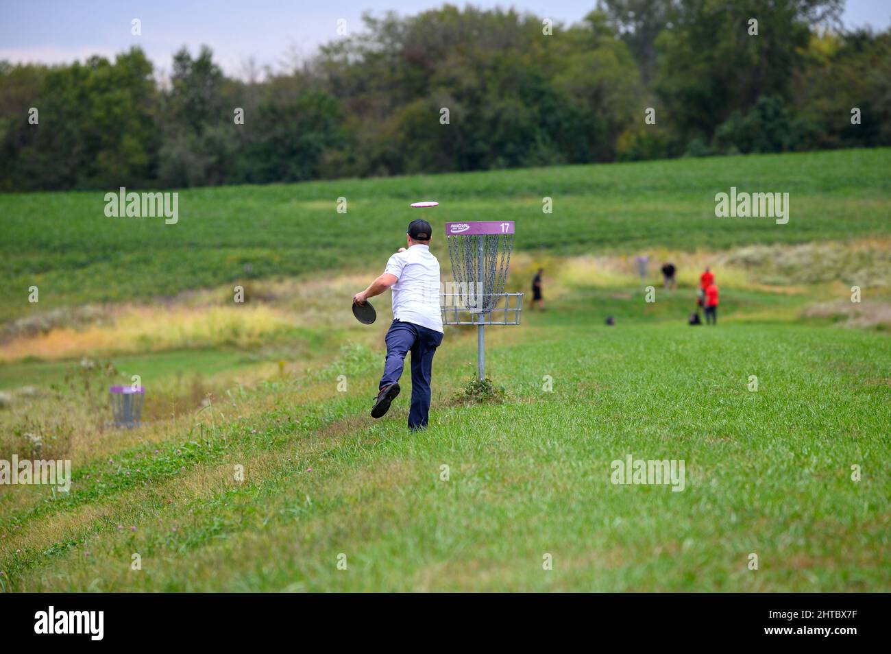 Disc golf player throwing a disc in the park Stock Photo - Alamy