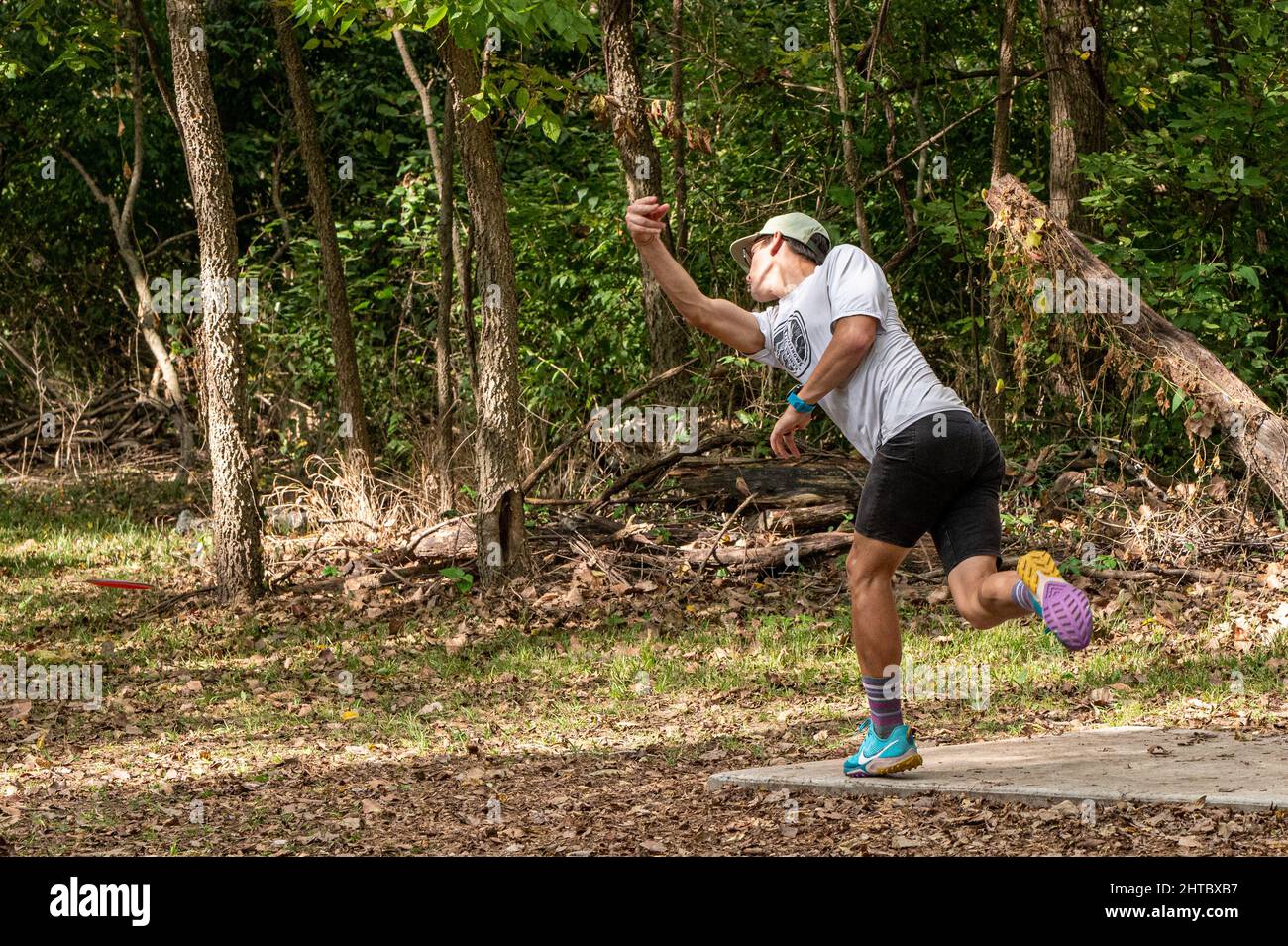 Disc golf player throwing a disc in the park Stock Photo - Alamy