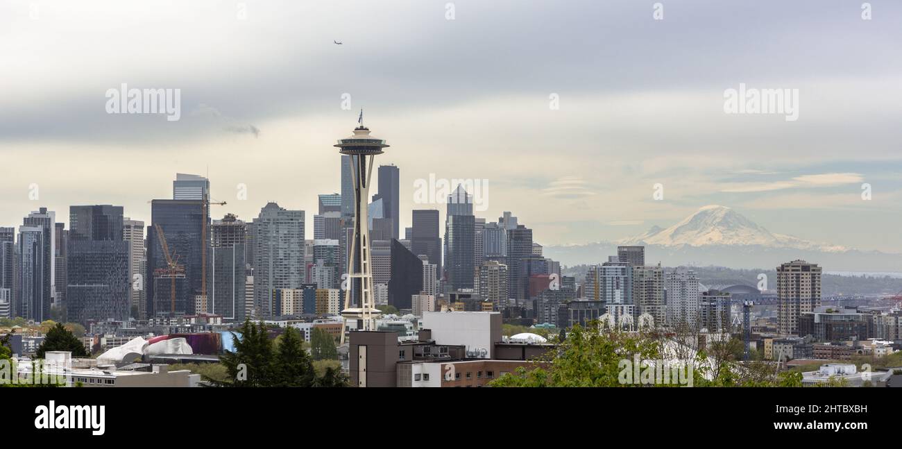 Scenic cityscape of the Seattle with a snowy mountain and dark clouds ...
