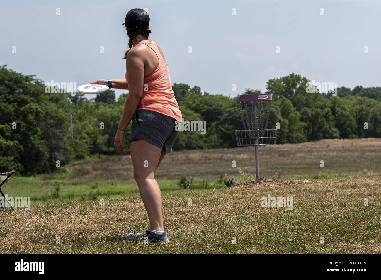 Woman playing disc frisbee golf Stock Photo - Alamy