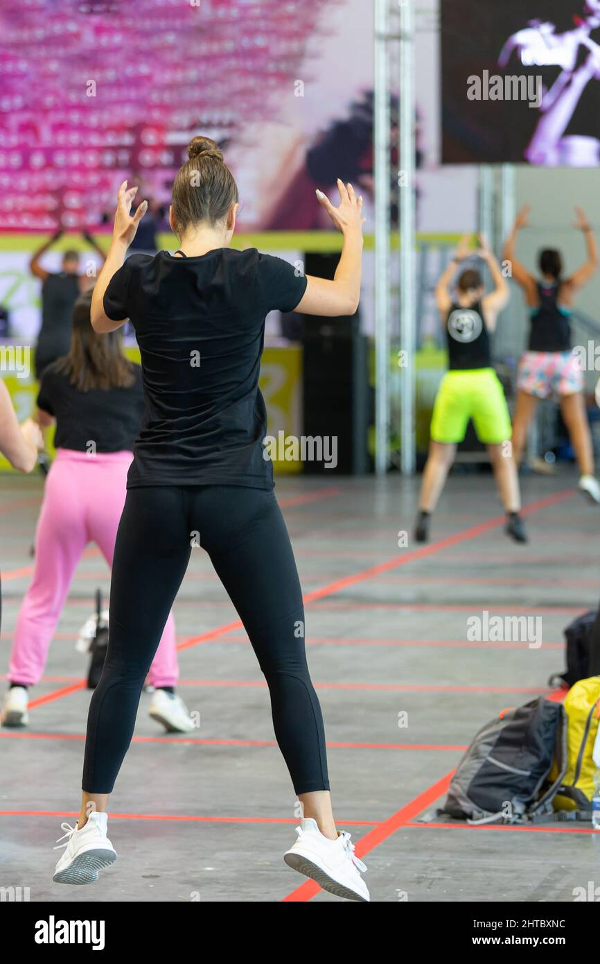Fitness Workout in Gym: People doing Exercises in Class with Music and ...