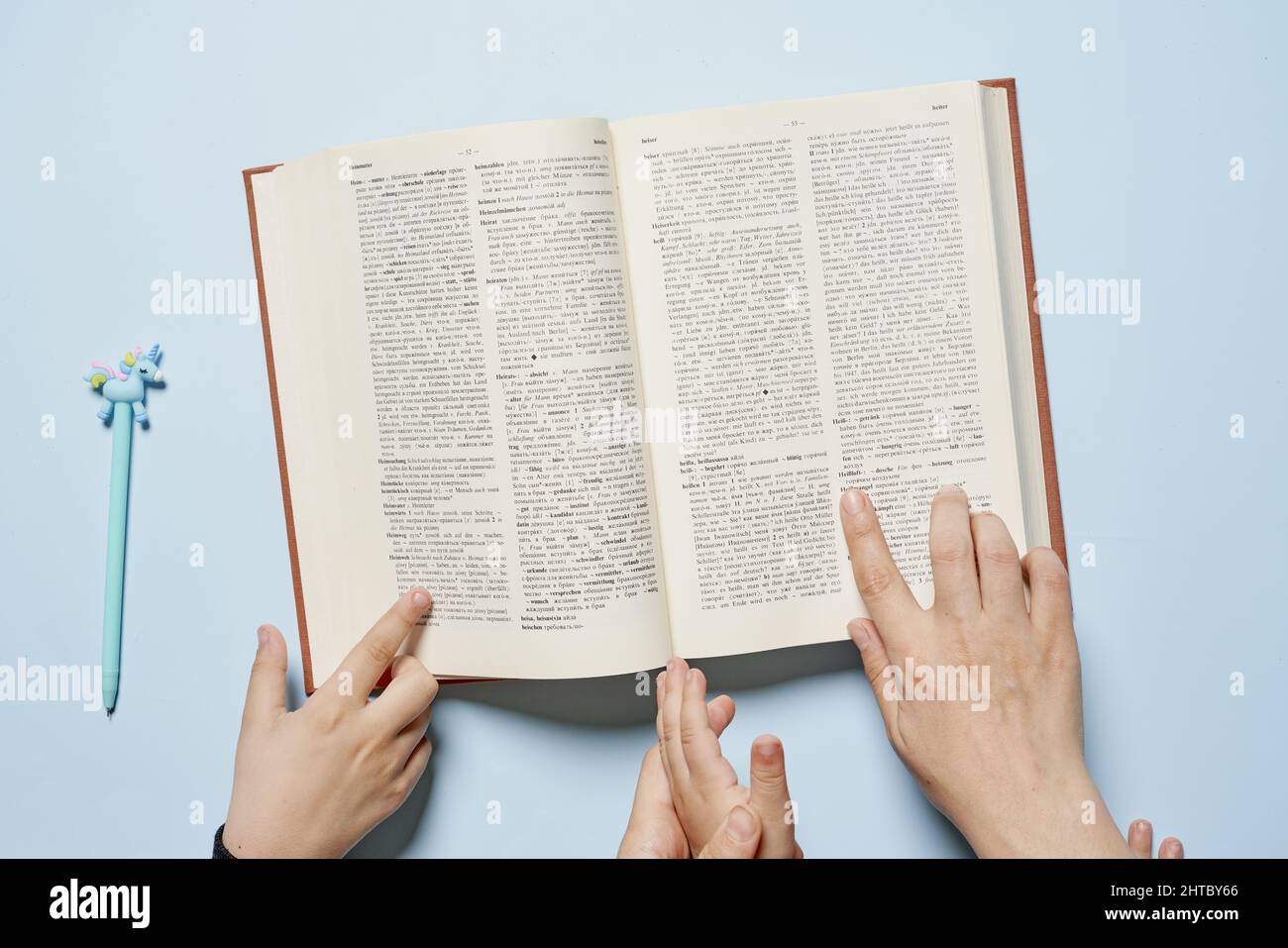 Top view of father and child hands checking a chapter of the book on ...