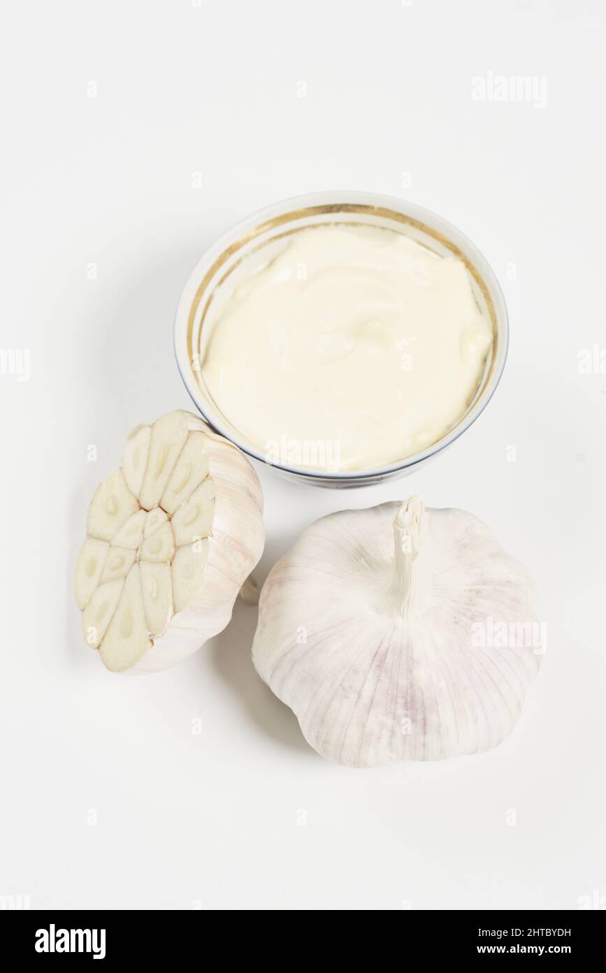 Fresh garlic and bowl of garlic sauce isolated on white background ...