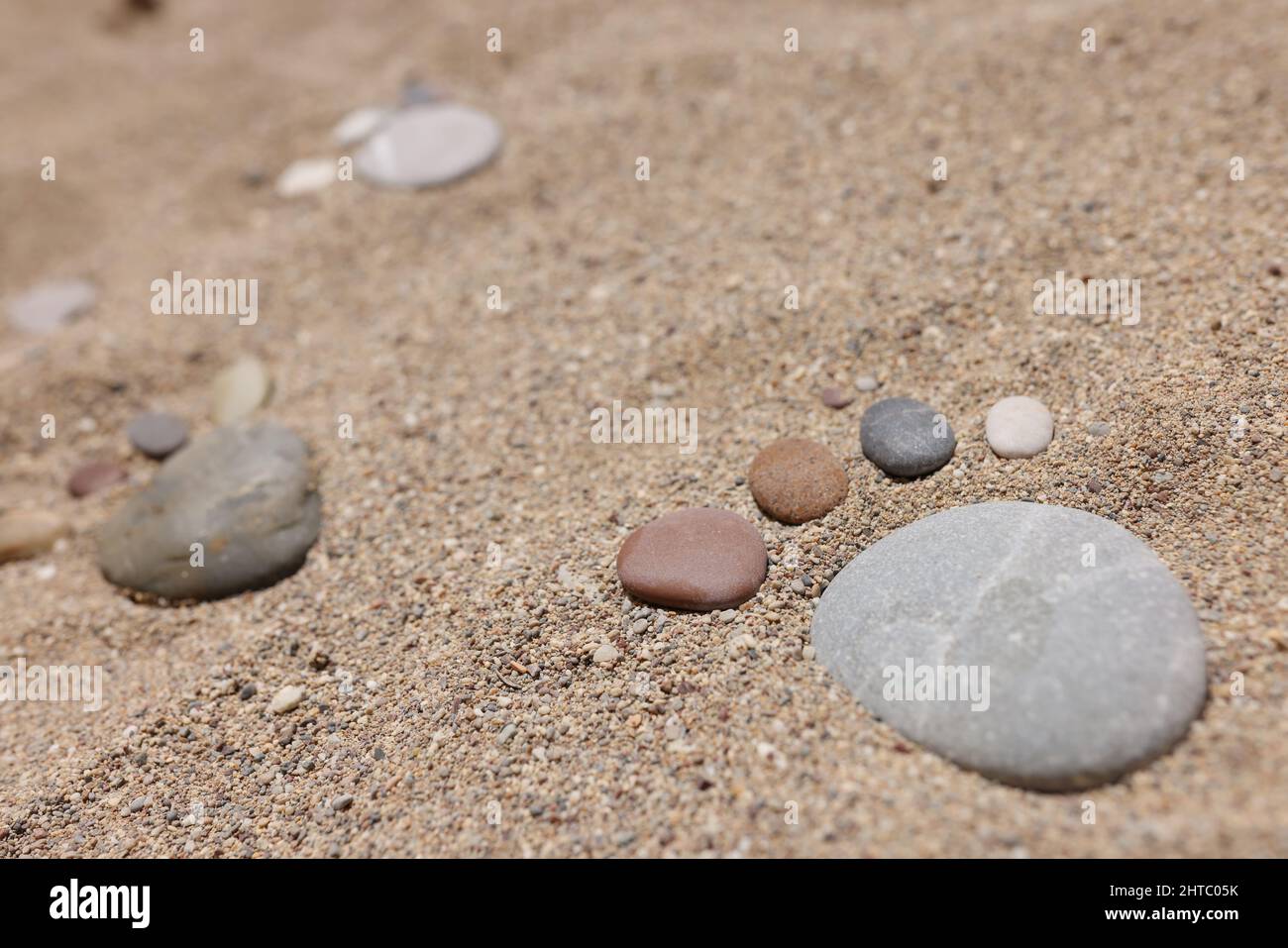 Stone put in human foot shape on sand, hot summer day, coastline, sandy ...