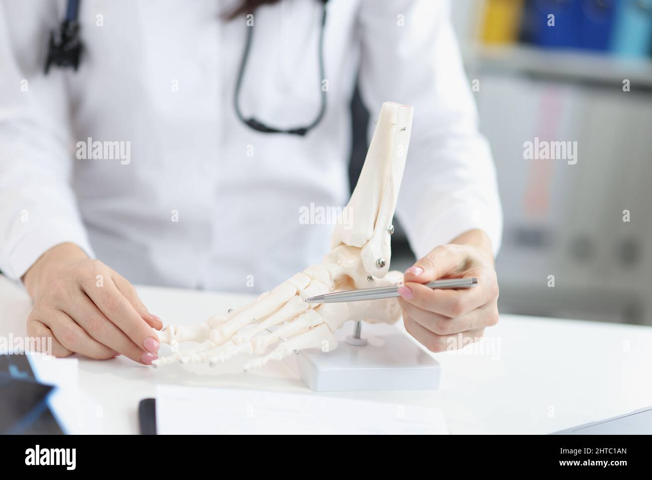 Orthopedic doctor show human plastic feet model, analyzing every bone ...